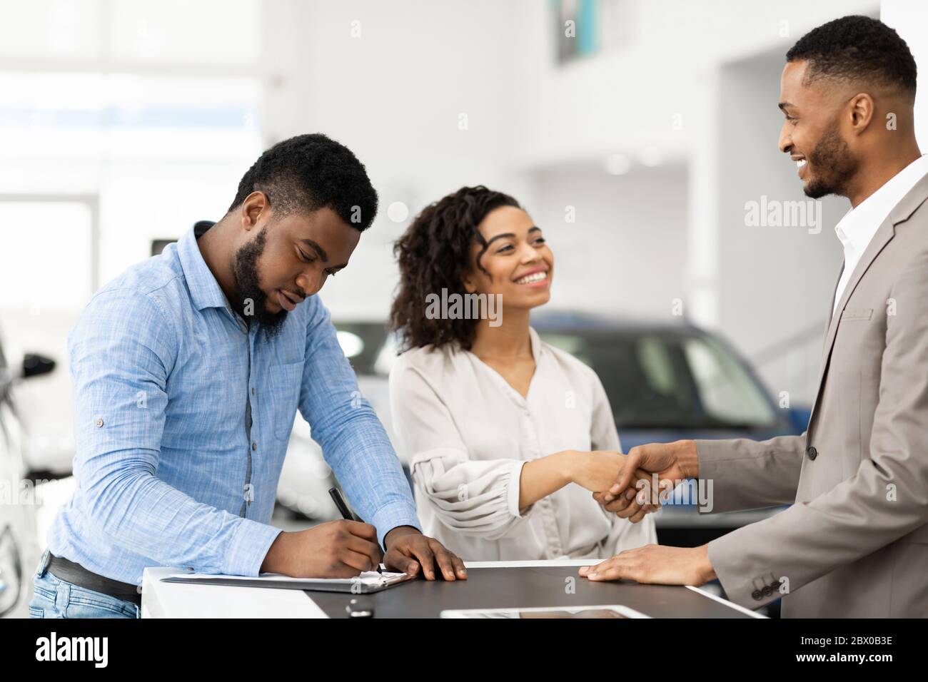 Signing papers at dealership hi-res stock photography and images - Alamy