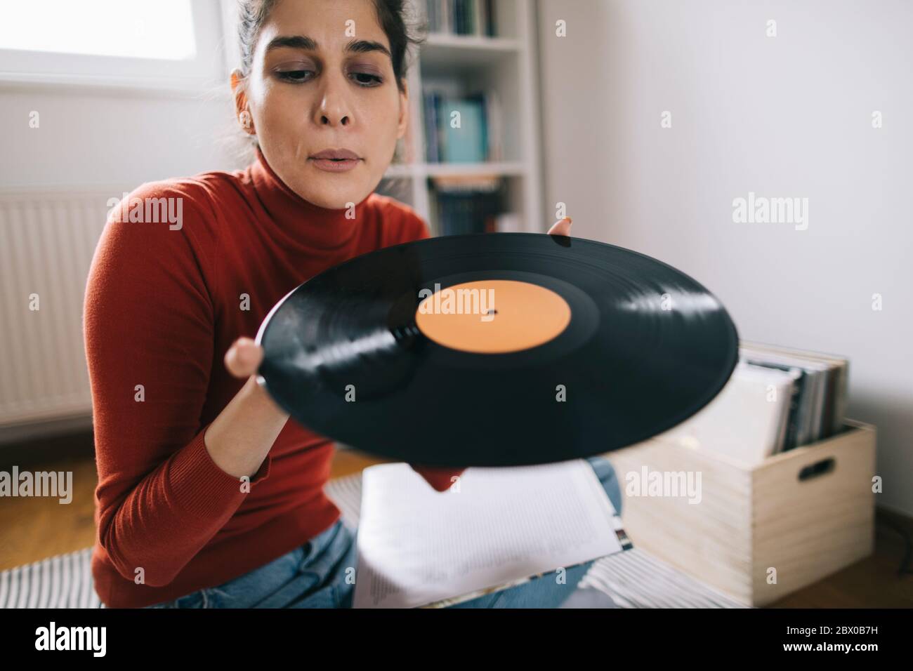 Young woman blowing dust form vinyl record Stock Photo - Alamy