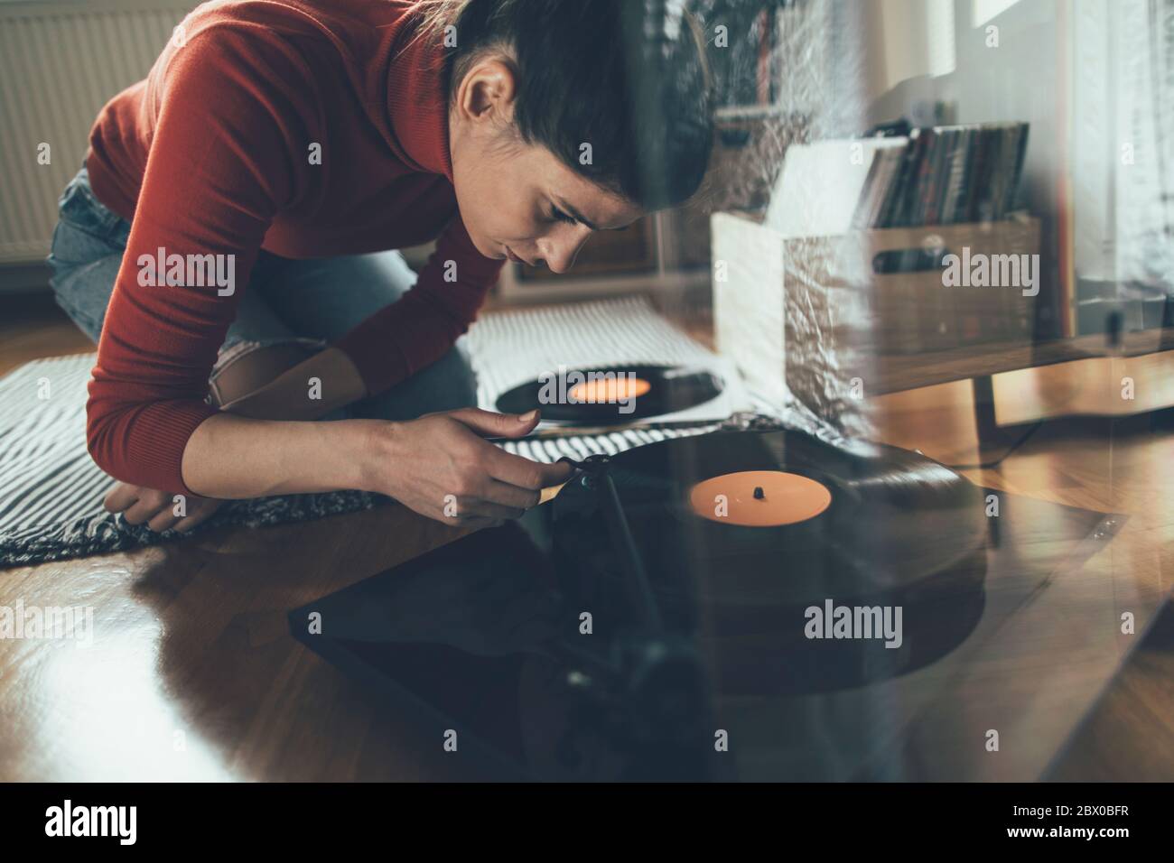 Young woman moving turntable tonearm over favorite song Stock Photo - Alamy