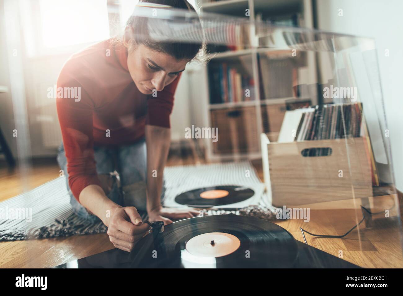 Young woman moving turntable tonearm over favorite song Stock Photo - Alamy