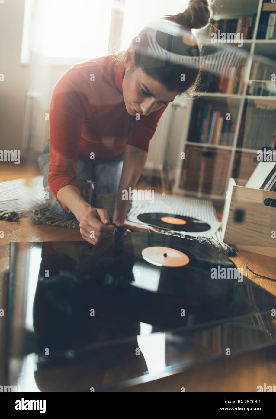 Young woman moving turntable tonearm over favorite song Stock Photo - Alamy