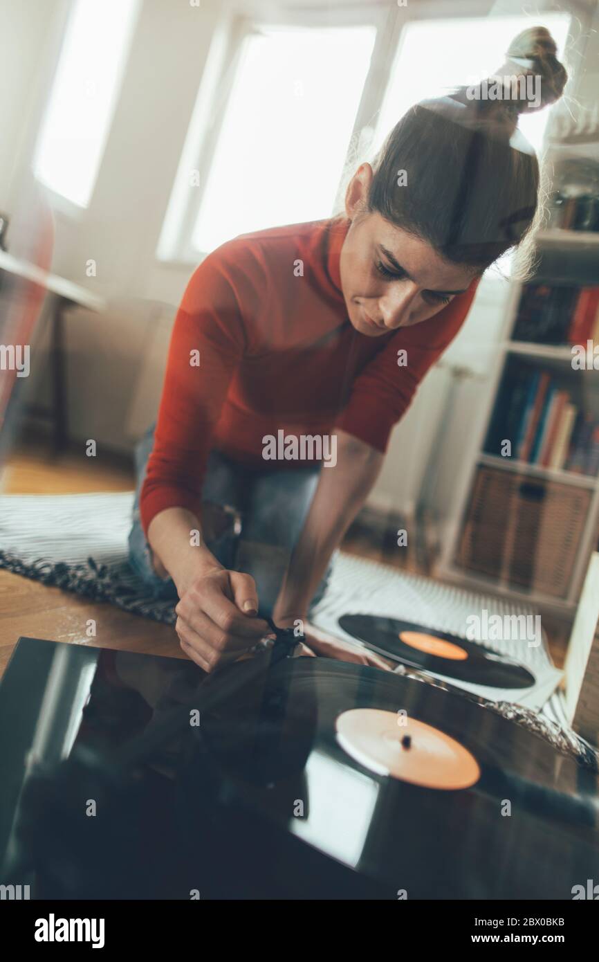 Young woman moving turntable tonearm over favorite song Stock Photo - Alamy