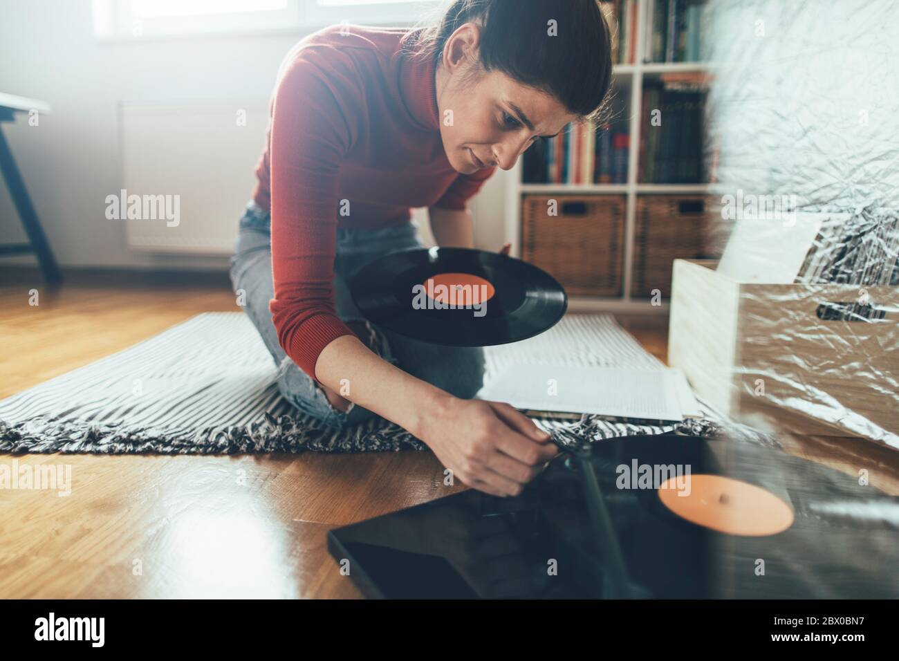Young woman moving turntable tonearm over favorite song Stock Photo - Alamy