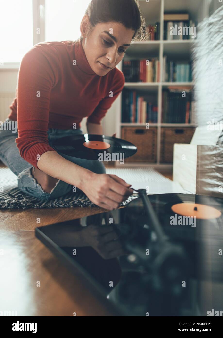 Young woman moving turntable tonearm over favorite song Stock Photo - Alamy
