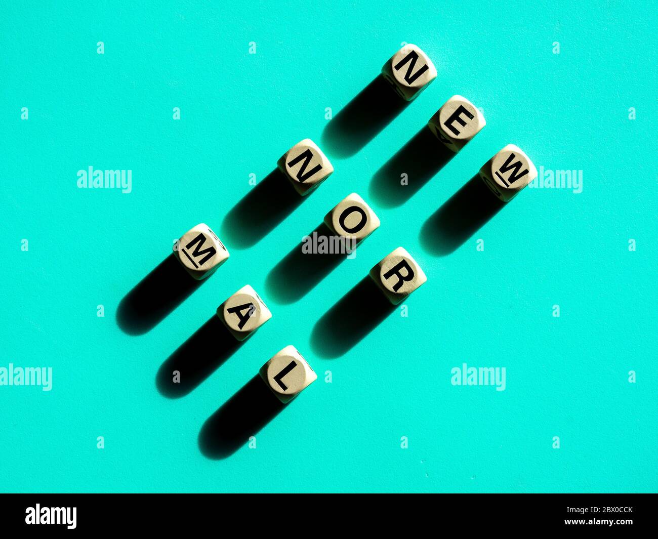 NEW NORMAL Word On Wooden Alphabet Cube On Light Green Background Top new-normal-word-on-wooden-alphabet-cube-on-light-green-background-top