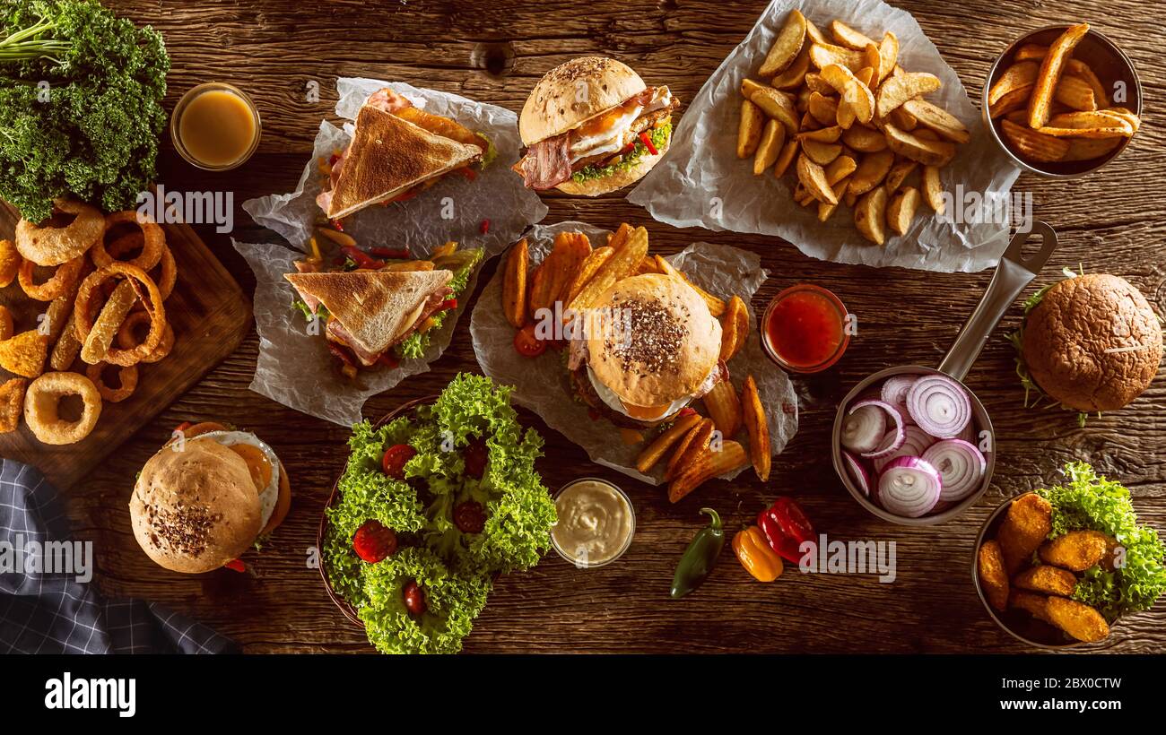 Top view of a table full of fast food, including hamburgers, potato ...