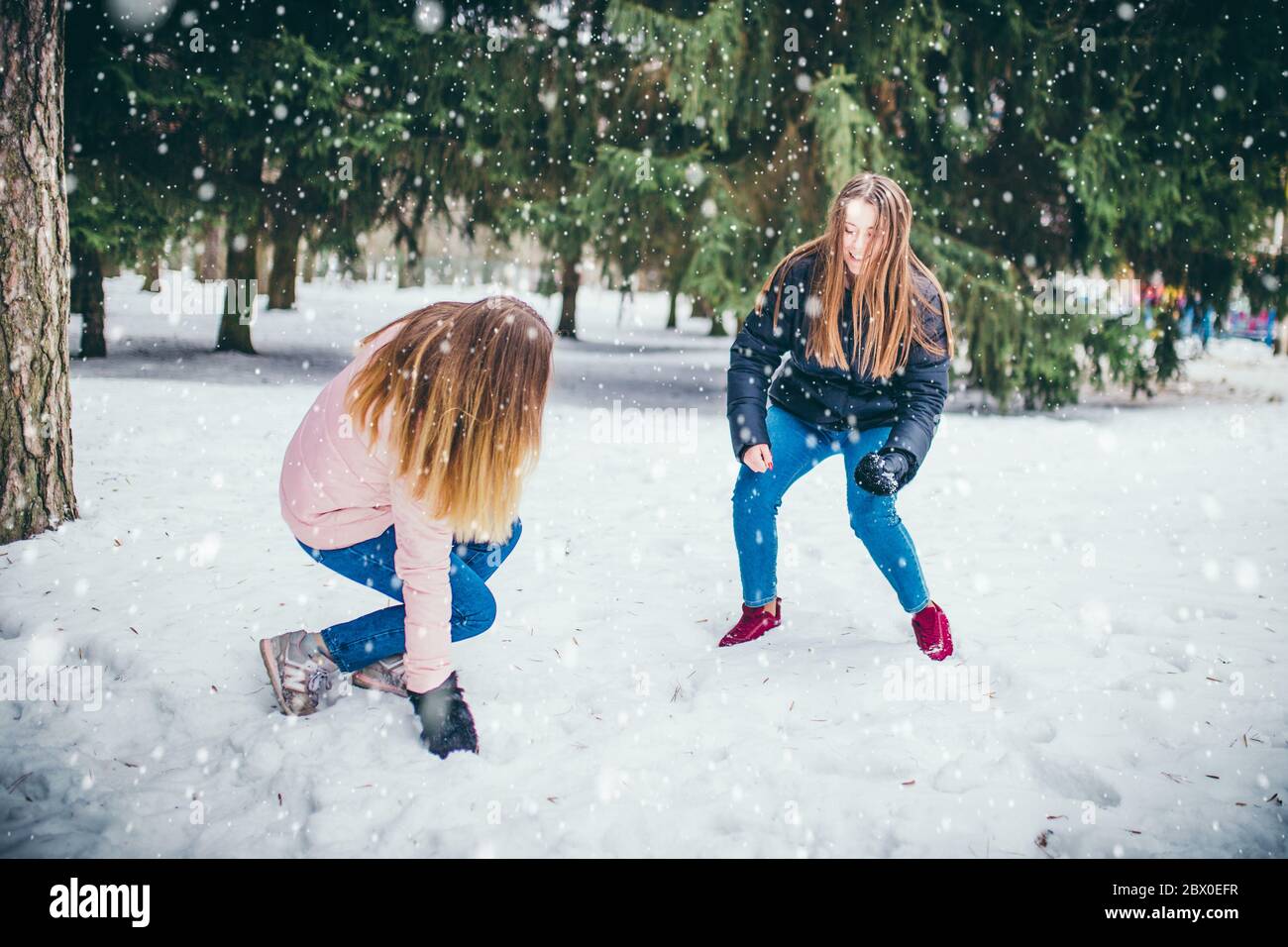 Winter fun and games on the street - playing snowballs - two young ...