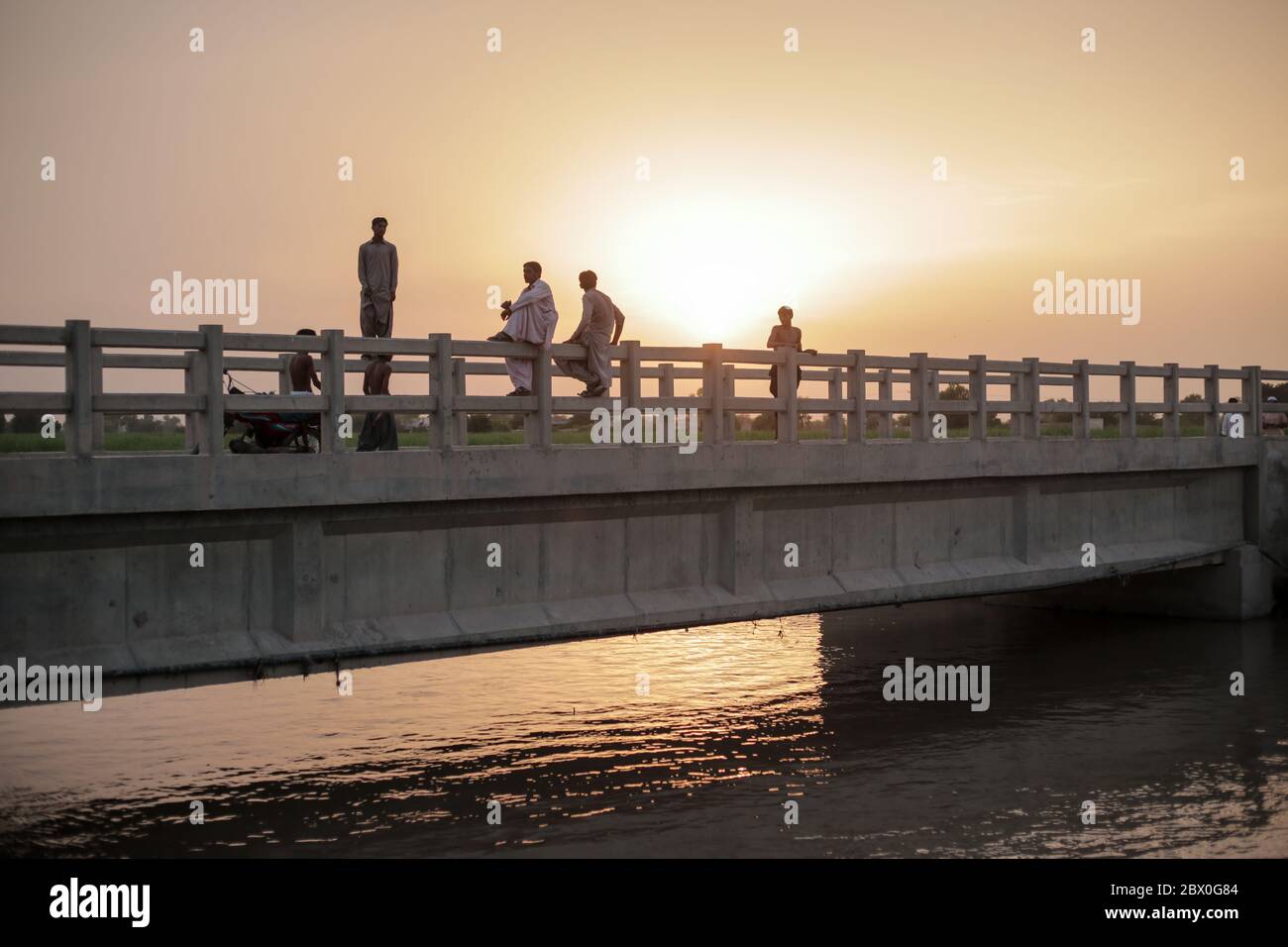 Kids Sitting Water From A Bridge During Sunset, In Moro, Sindh ...