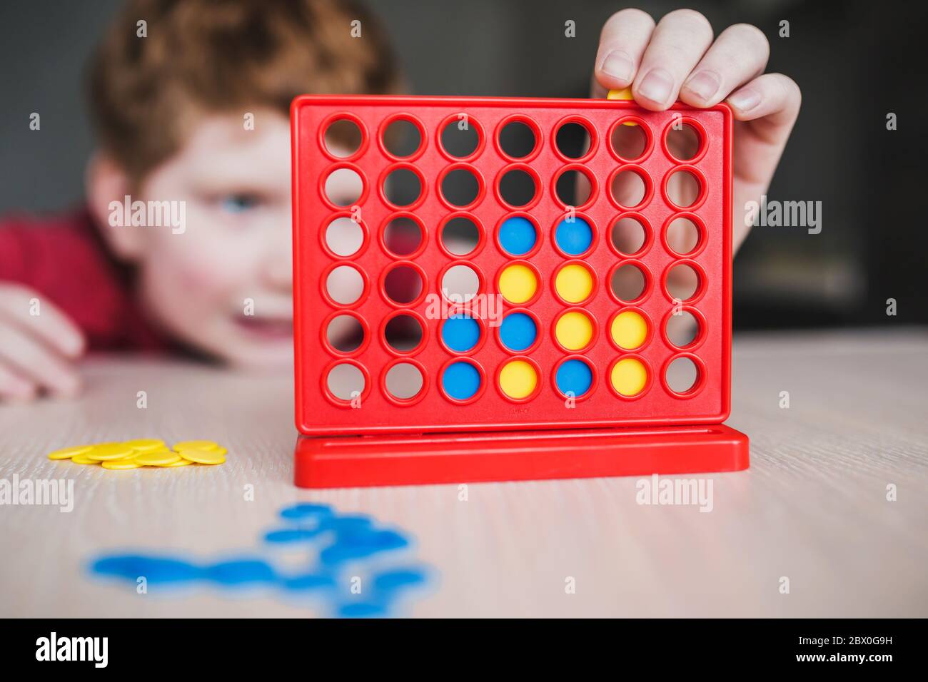 The child makes a move to the board game "collect four in a line ...