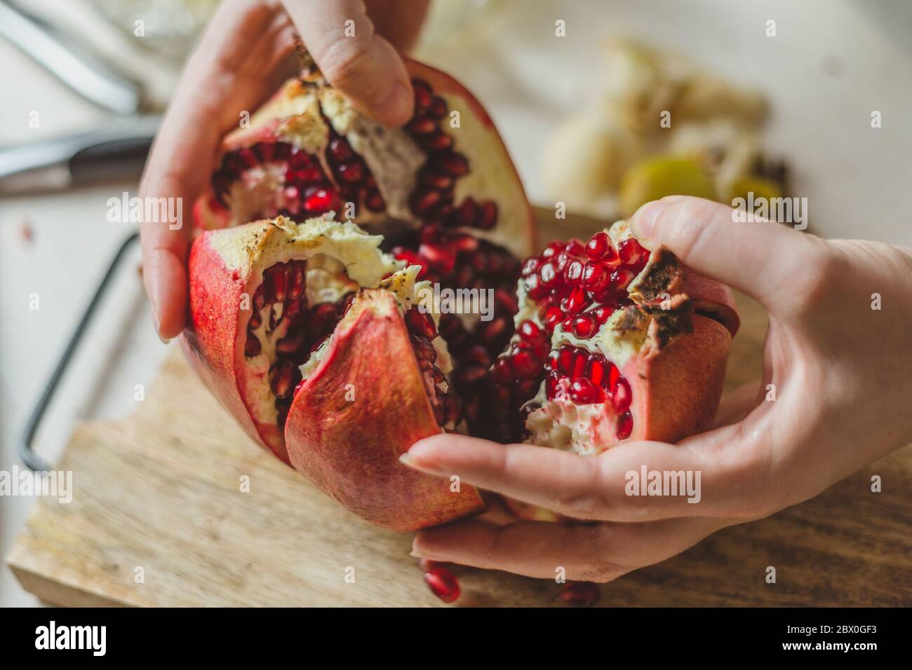Hands opening pomegranate hi-res stock photography and images - Alamy
