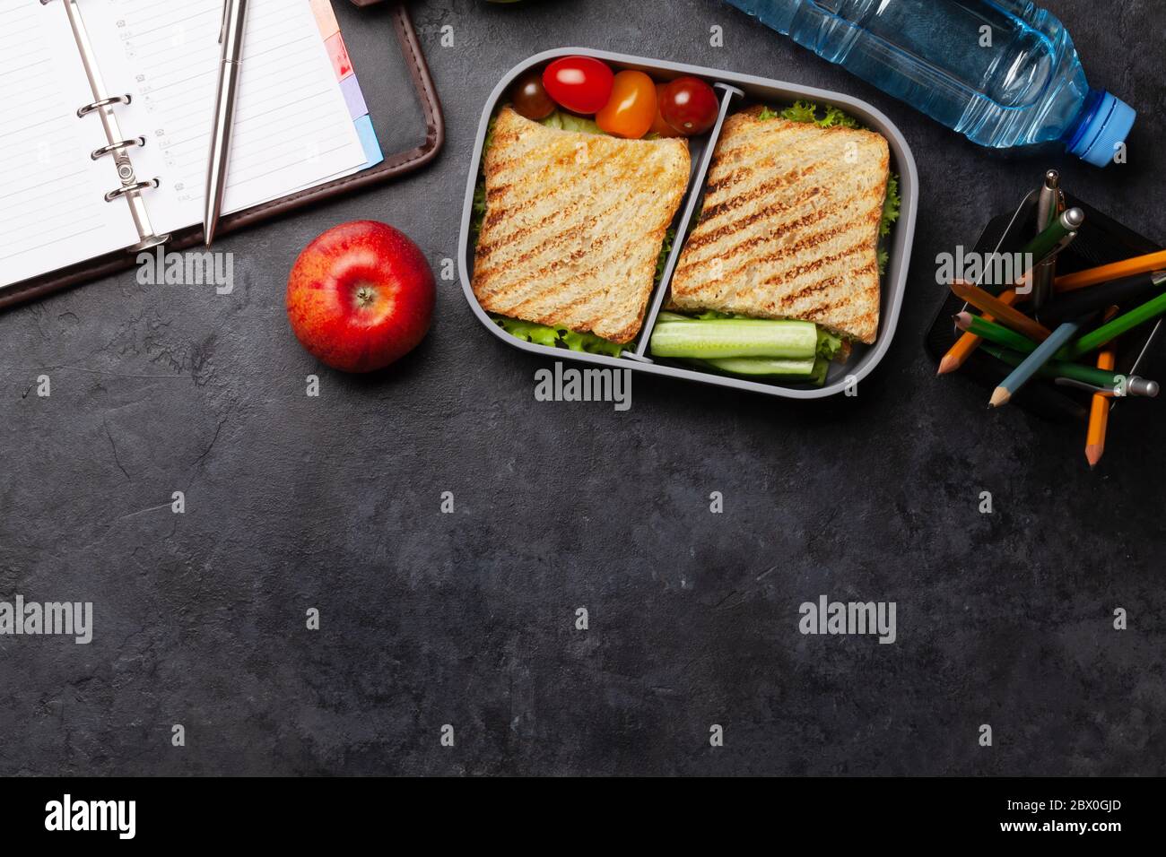 Healthy lunch box with sandwich and vegetables on office table. Top ...