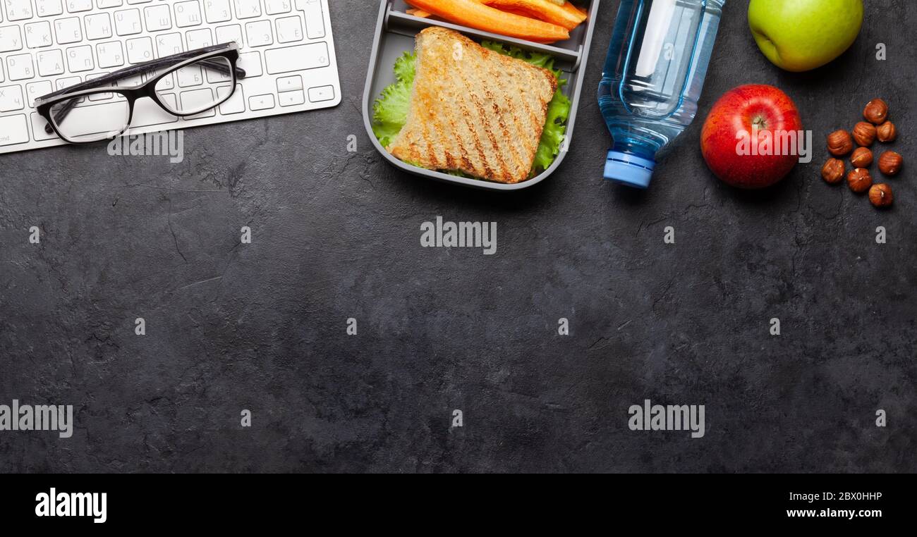 Healthy lunch box with sandwich and vegetables on office table. Top ...