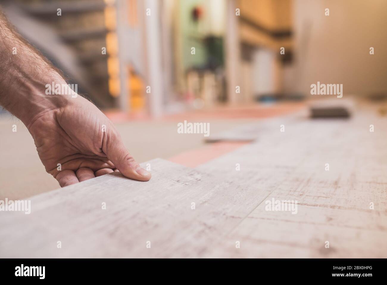 Close-up of master's hand connects laminate lock when laying flooring ...
