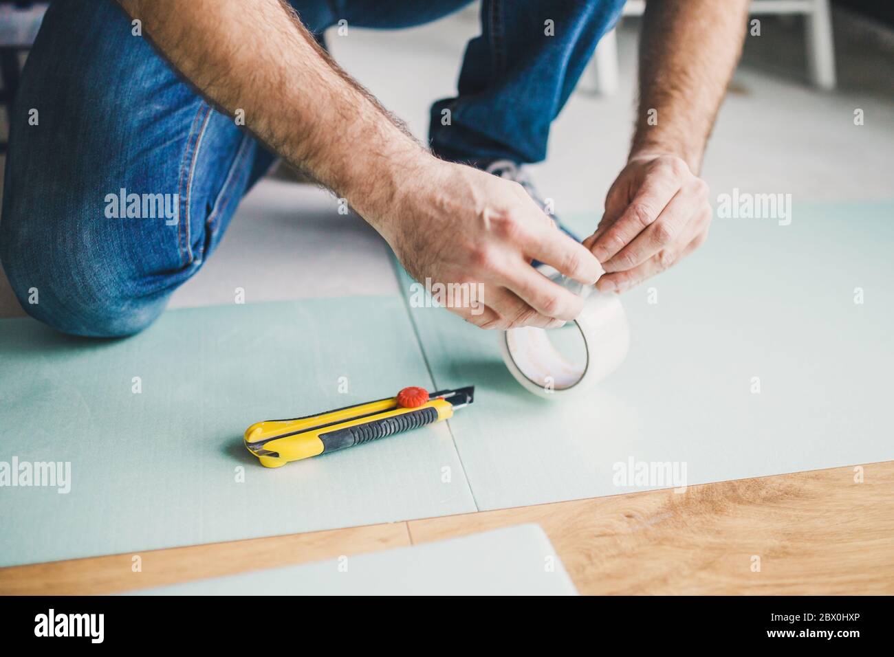 European man working at home - laying polystyrene substrate for laying ...