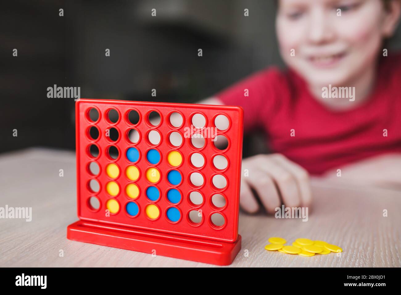 A boy is having fun playing a board game four in line Stock Photo - Alamy