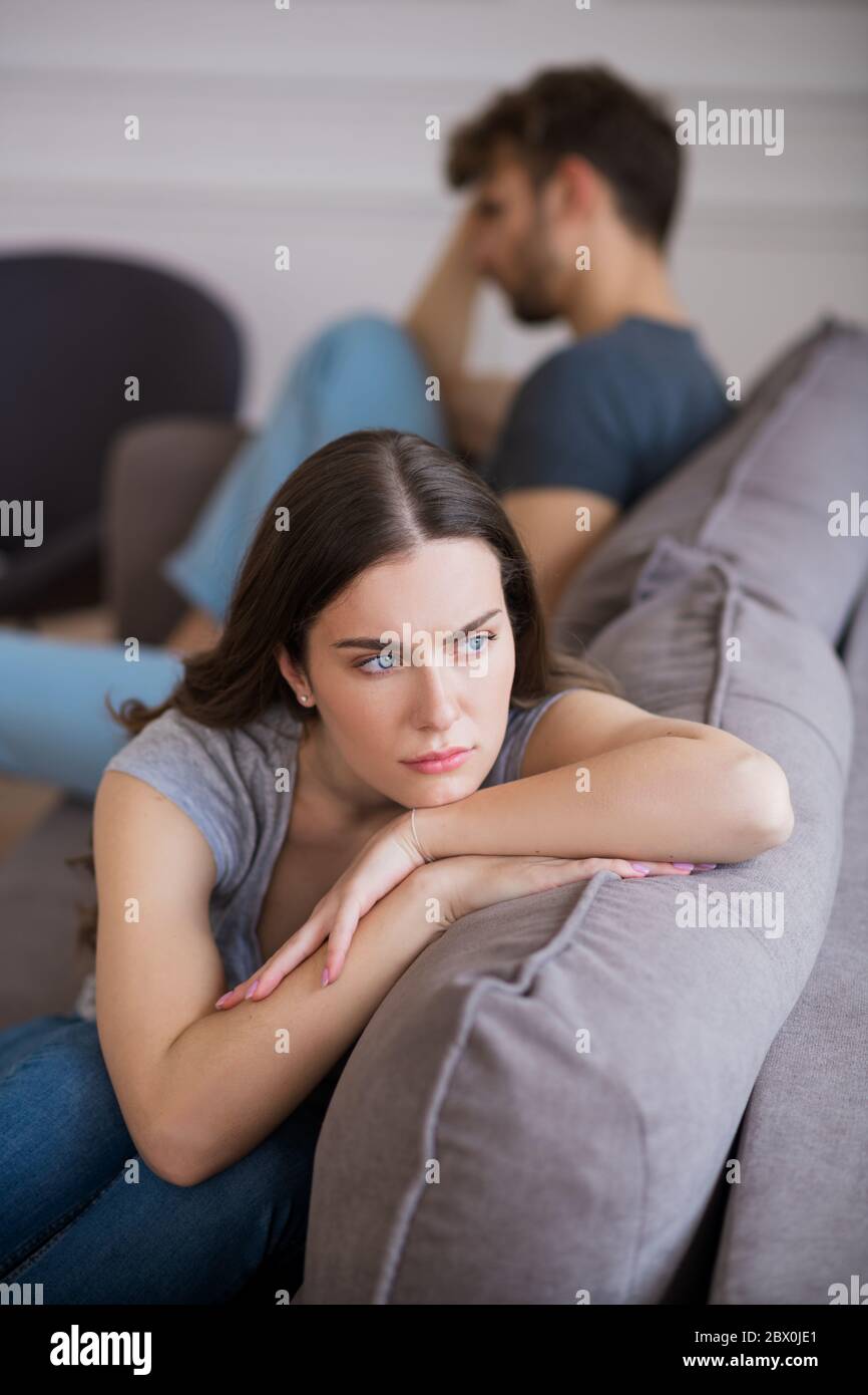 Young woman sitting with a depressed look after a bad talk with her ...