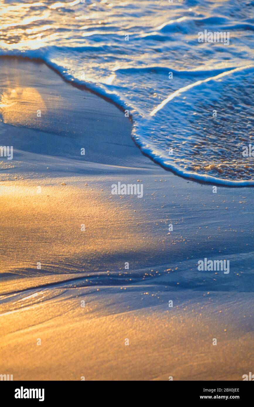 Incoming whitewater flowing onto folds of wet sand Stock Photo - Alamy