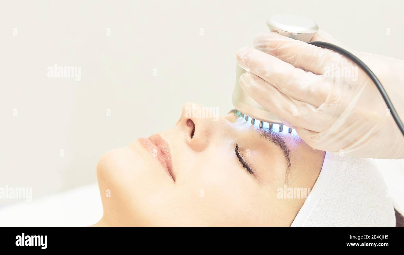 Light infrared therapy. Cosmetology head procedure. Beauty woman face ...