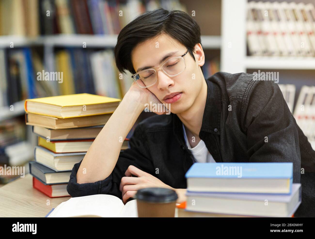 Tired student napping in the university library Stock Photo - Alamy