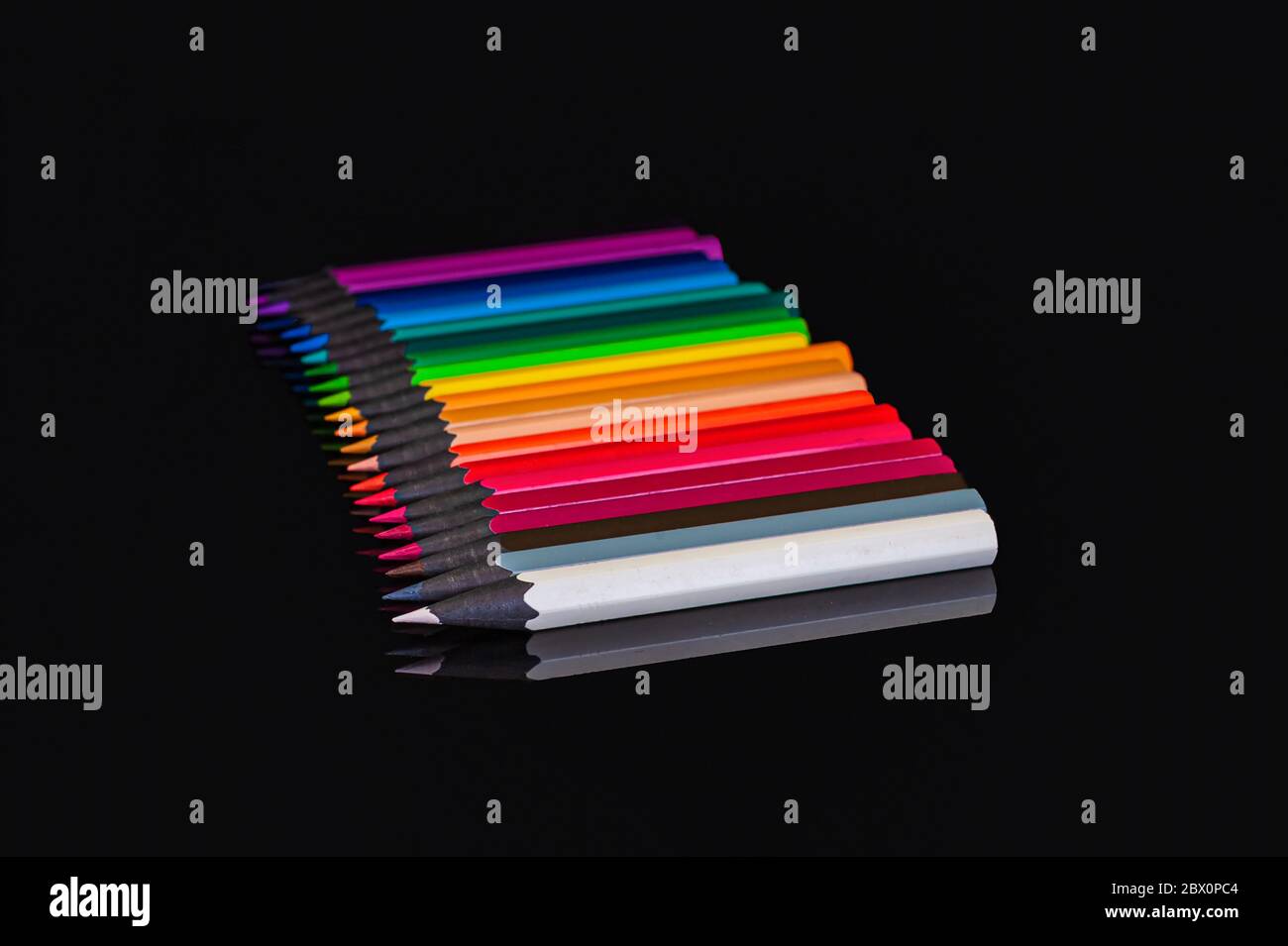 many colored pencils of different colors on an isolated black ...