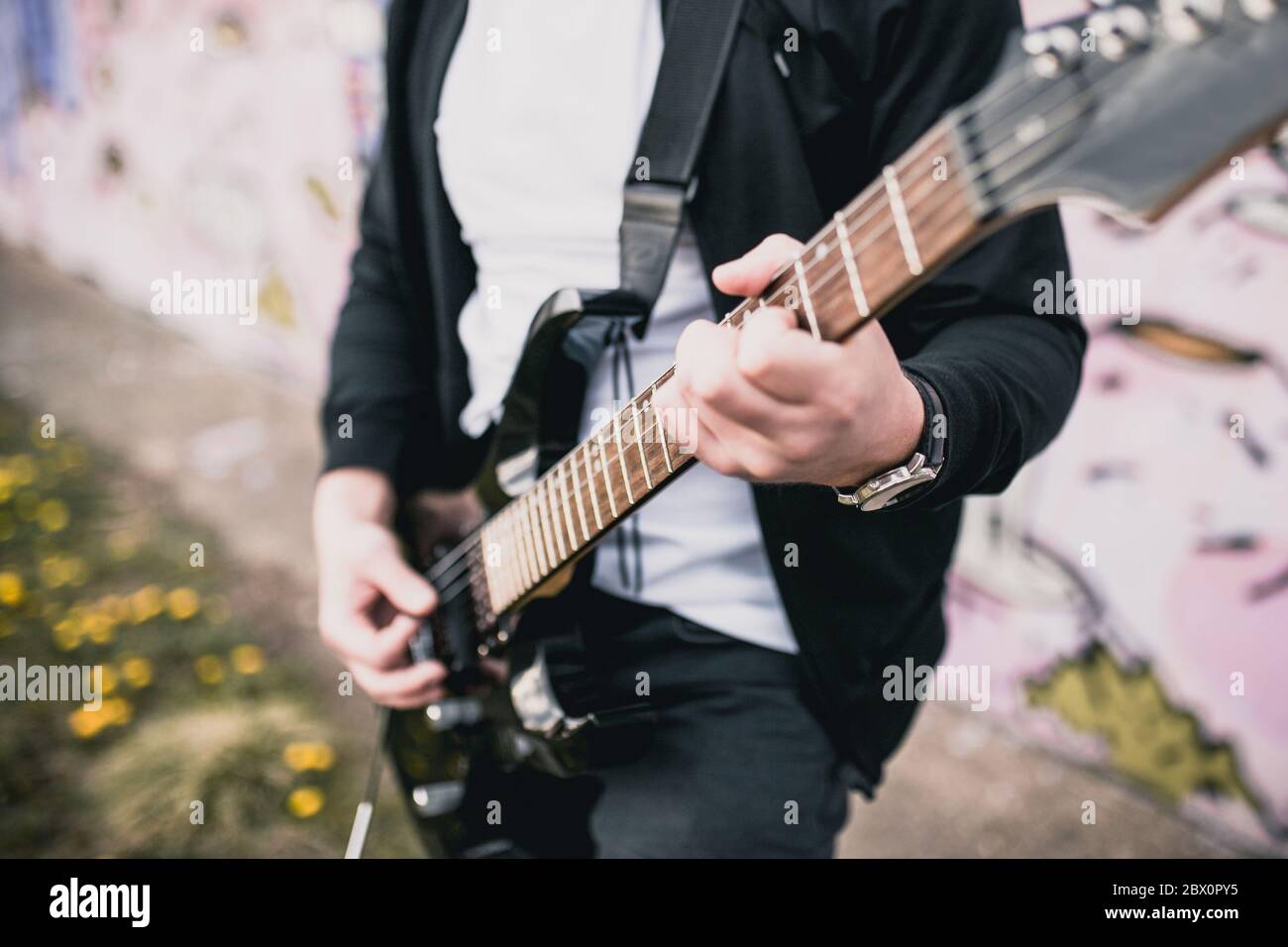 Technique of playing the electric guitar - a man playing outdoors ...
