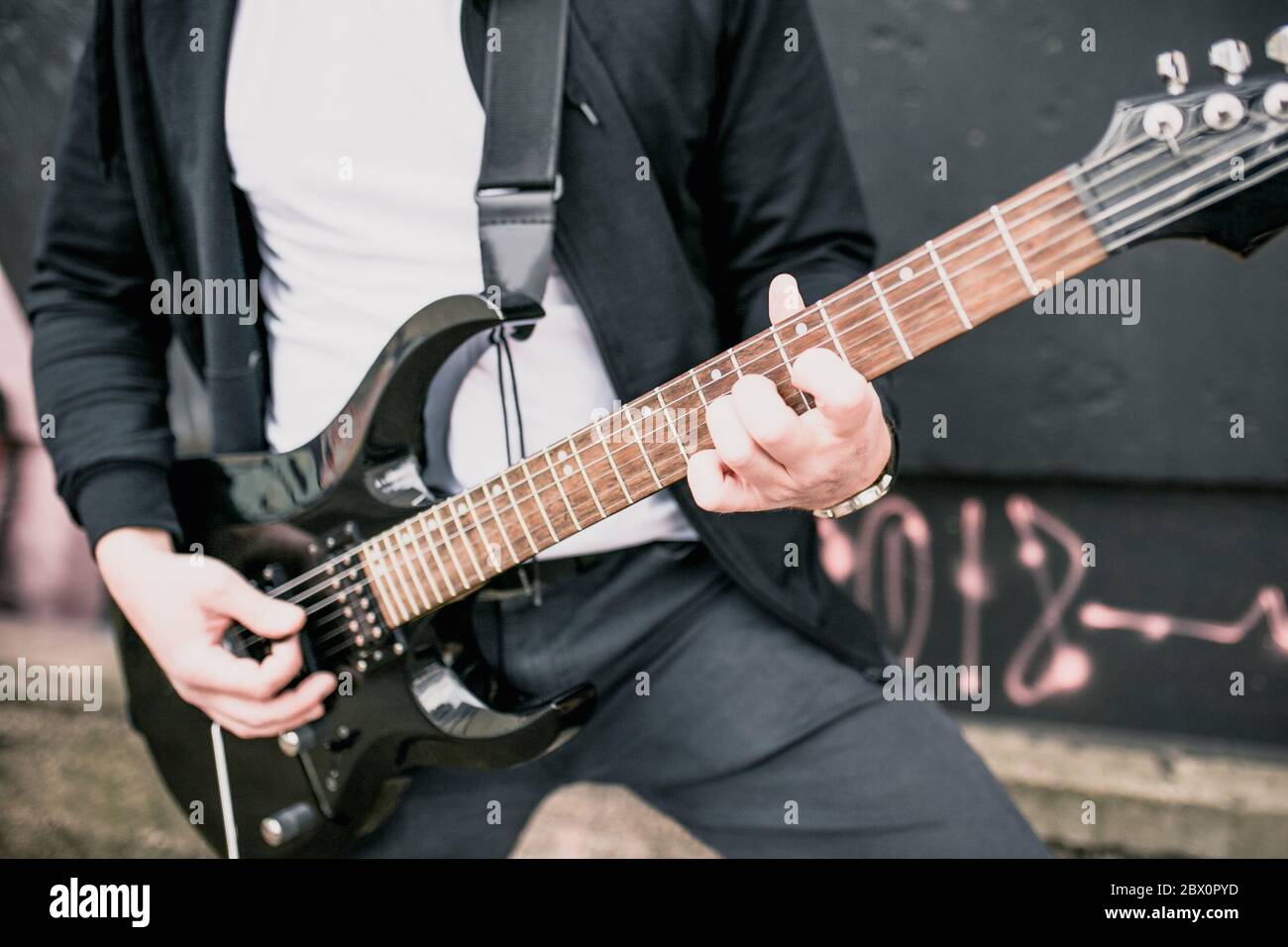 Technique of playing the electric guitar - a man playing outdoors ...