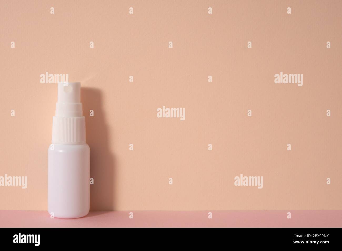 Pink color background and small spray container Stock Photo - Alamy