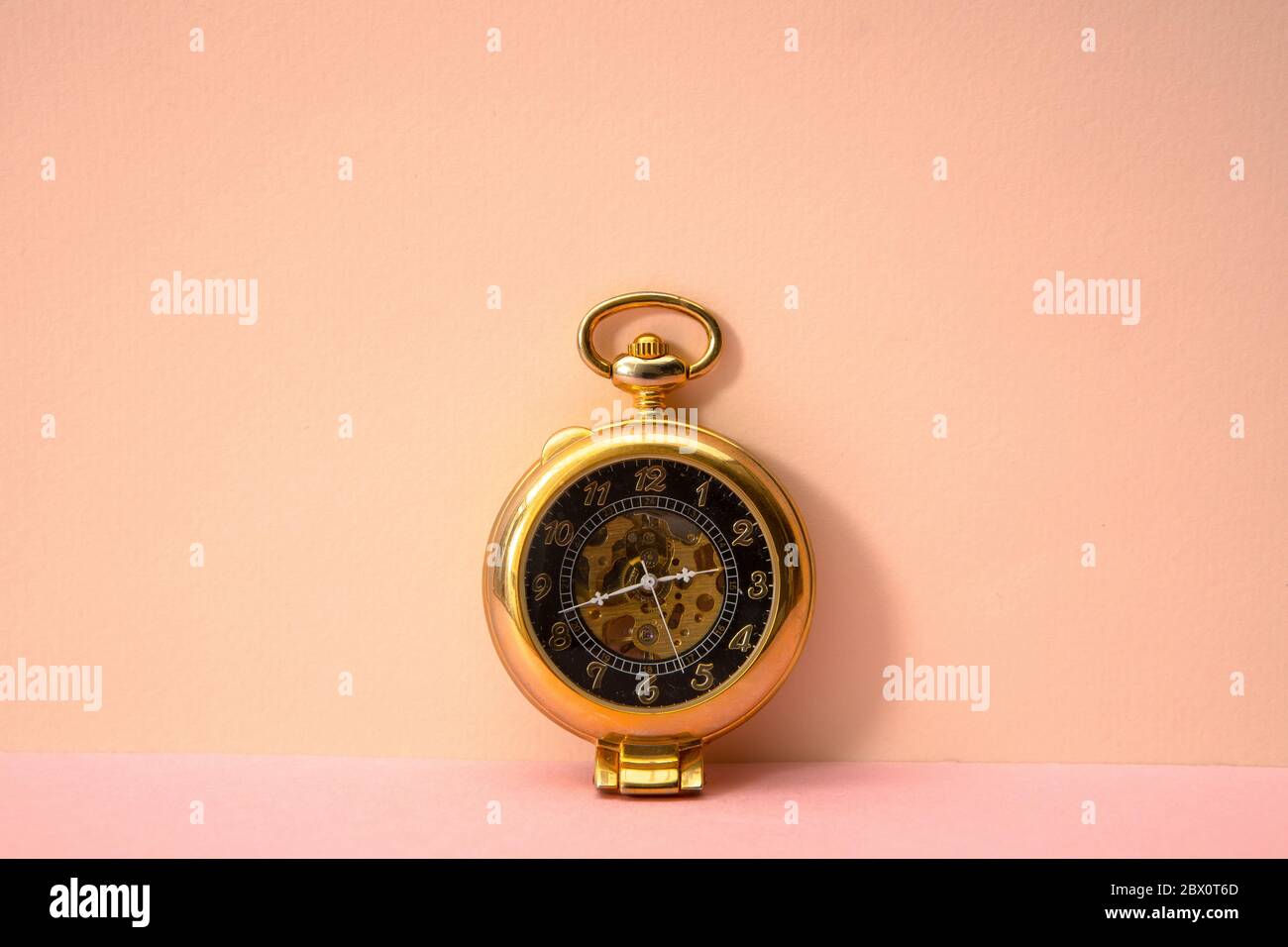 Pink color background and classic golden pocket watch Stock Photo - Alamy