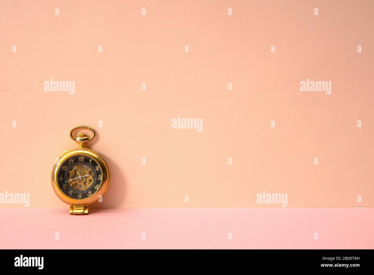 Pink color background and classic golden pocket watch Stock Photo - Alamy