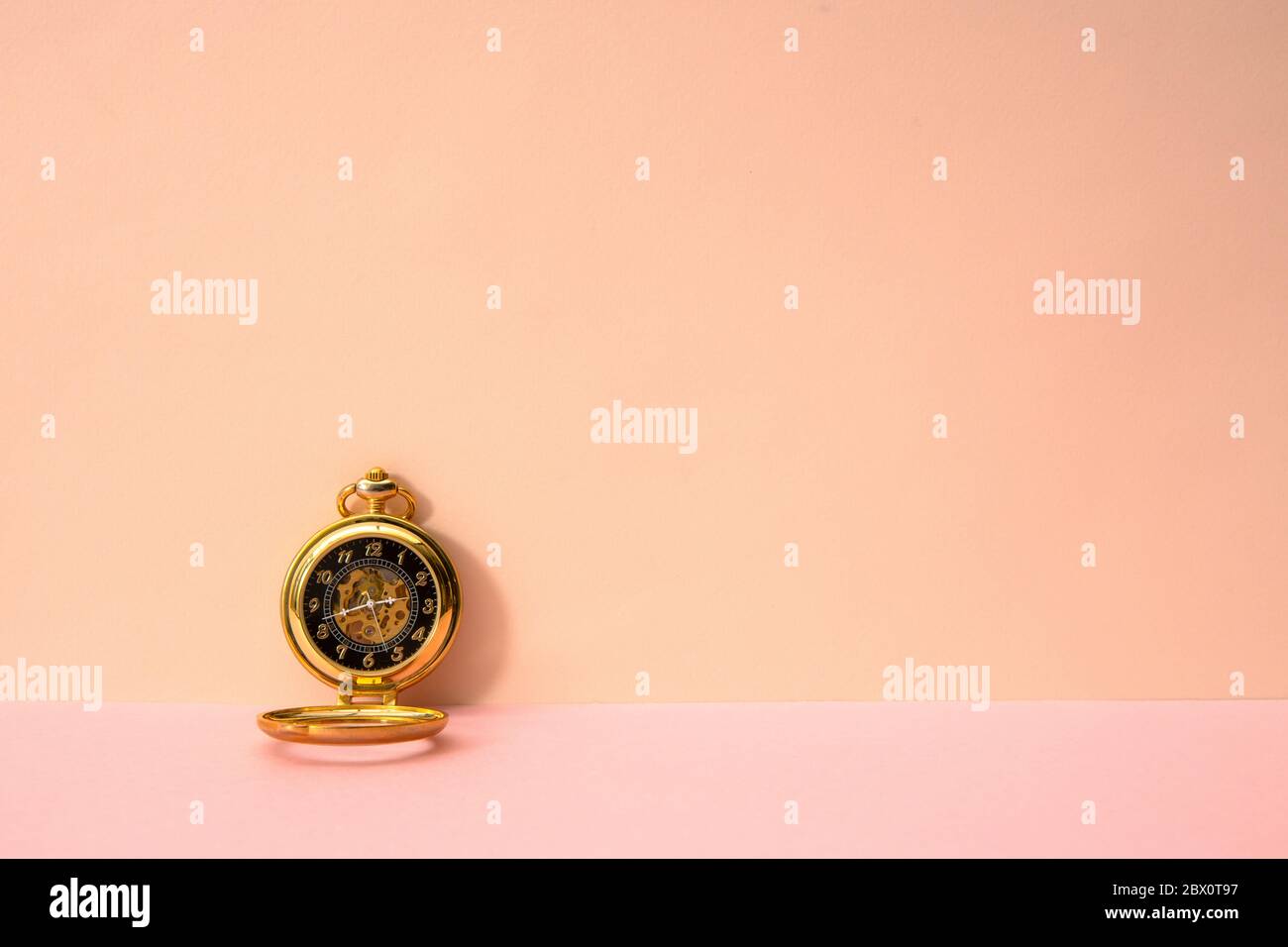 Pink color background and classic golden pocket watch Stock Photo - Alamy