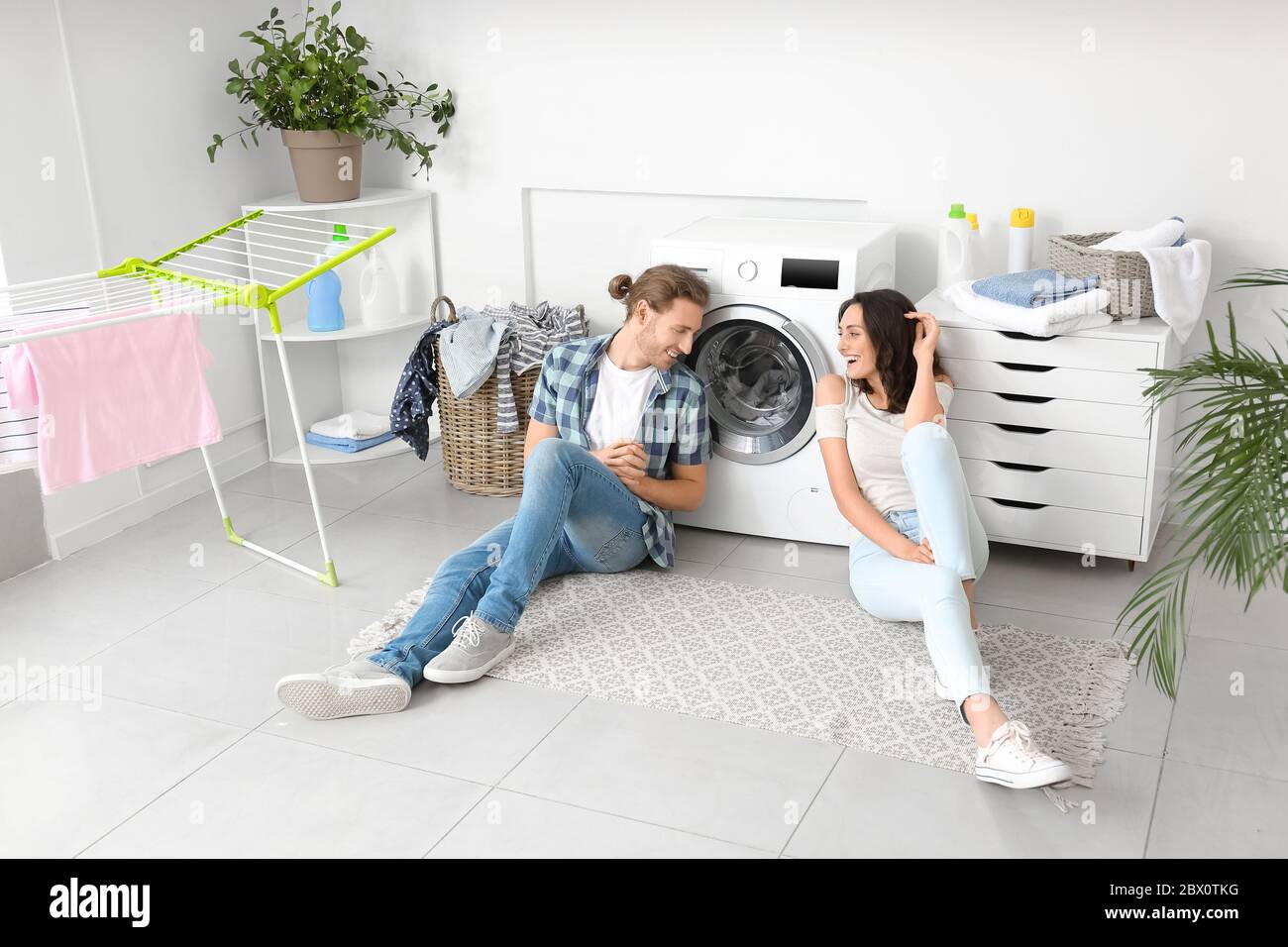 Happy young couple doing laundry at home Stock Photo - Alamy