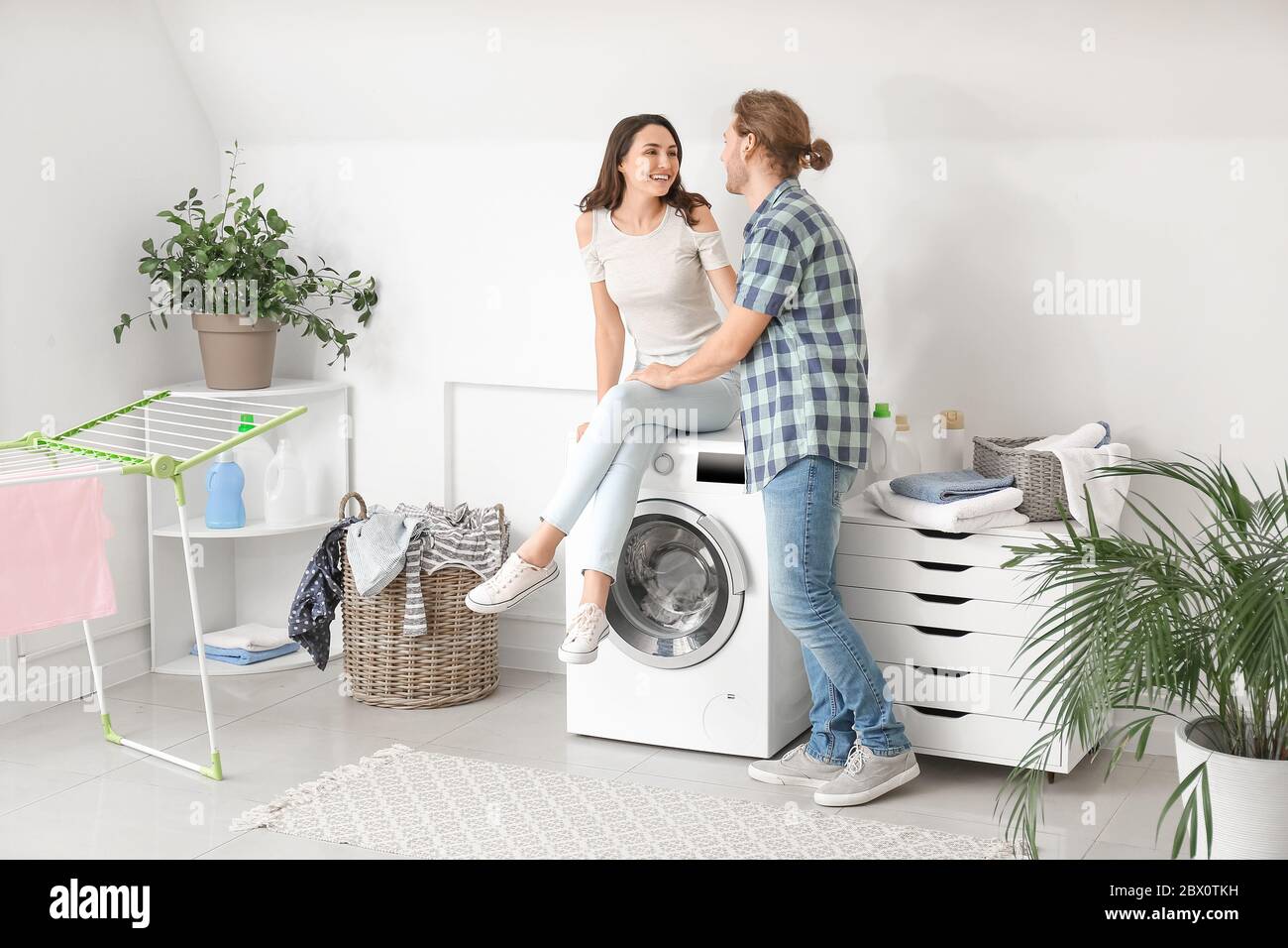 Happy young couple doing laundry at home Stock Photo - Alamy