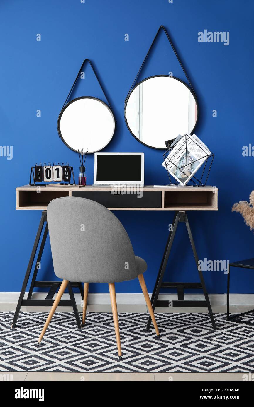 Interior of modern room with workplace and mirrors Stock Photo - Alamy