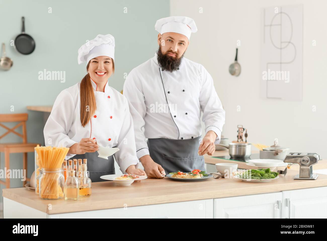 Male and female chefs cooking in kitchen Stock Photo - Alamy