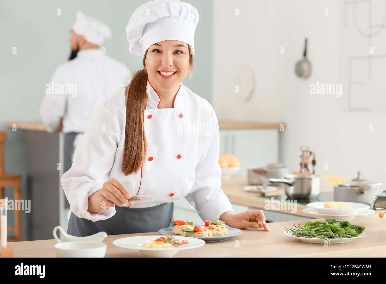 Female chef cooking in kitchen Stock Photo - Alamy