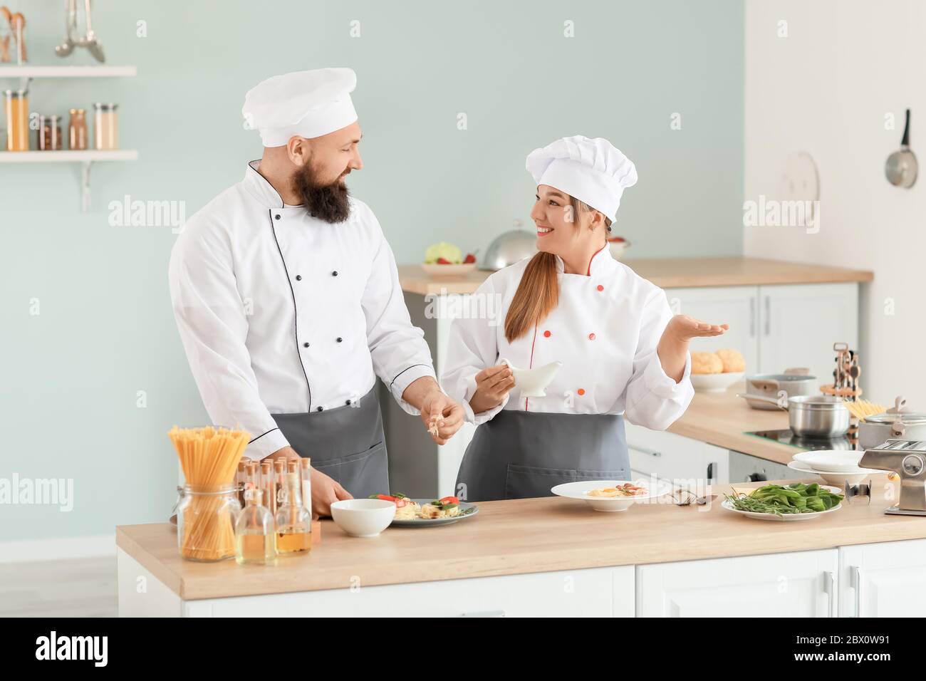 Male and female chefs cooking in kitchen Stock Photo - Alamy