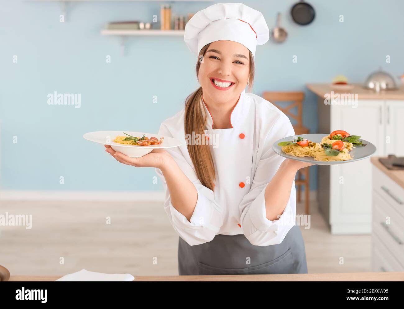 Female chef with tasty dishes in kitchen Stock Photo - Alamy