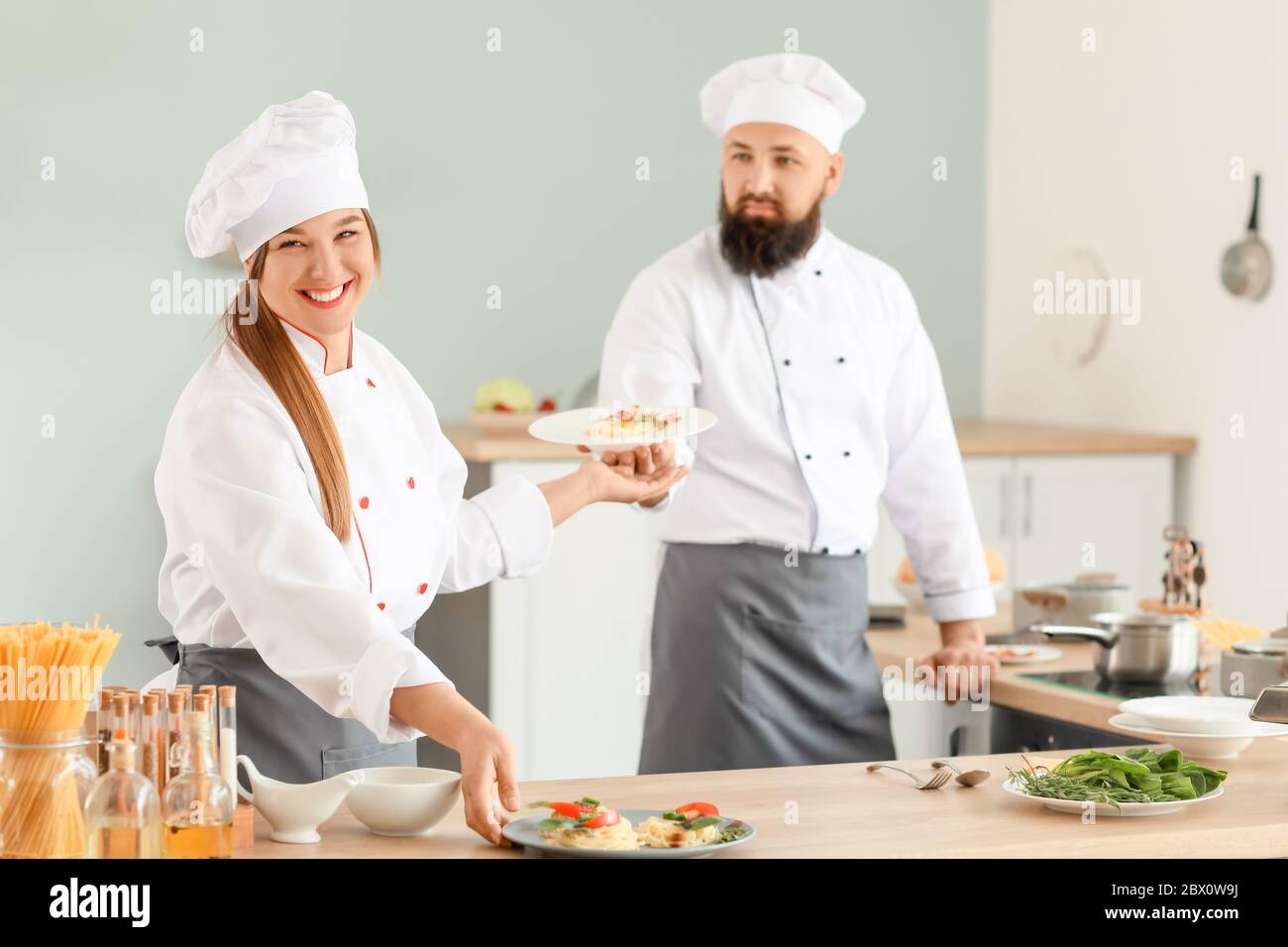Male and female chefs cooking in kitchen Stock Photo - Alamy