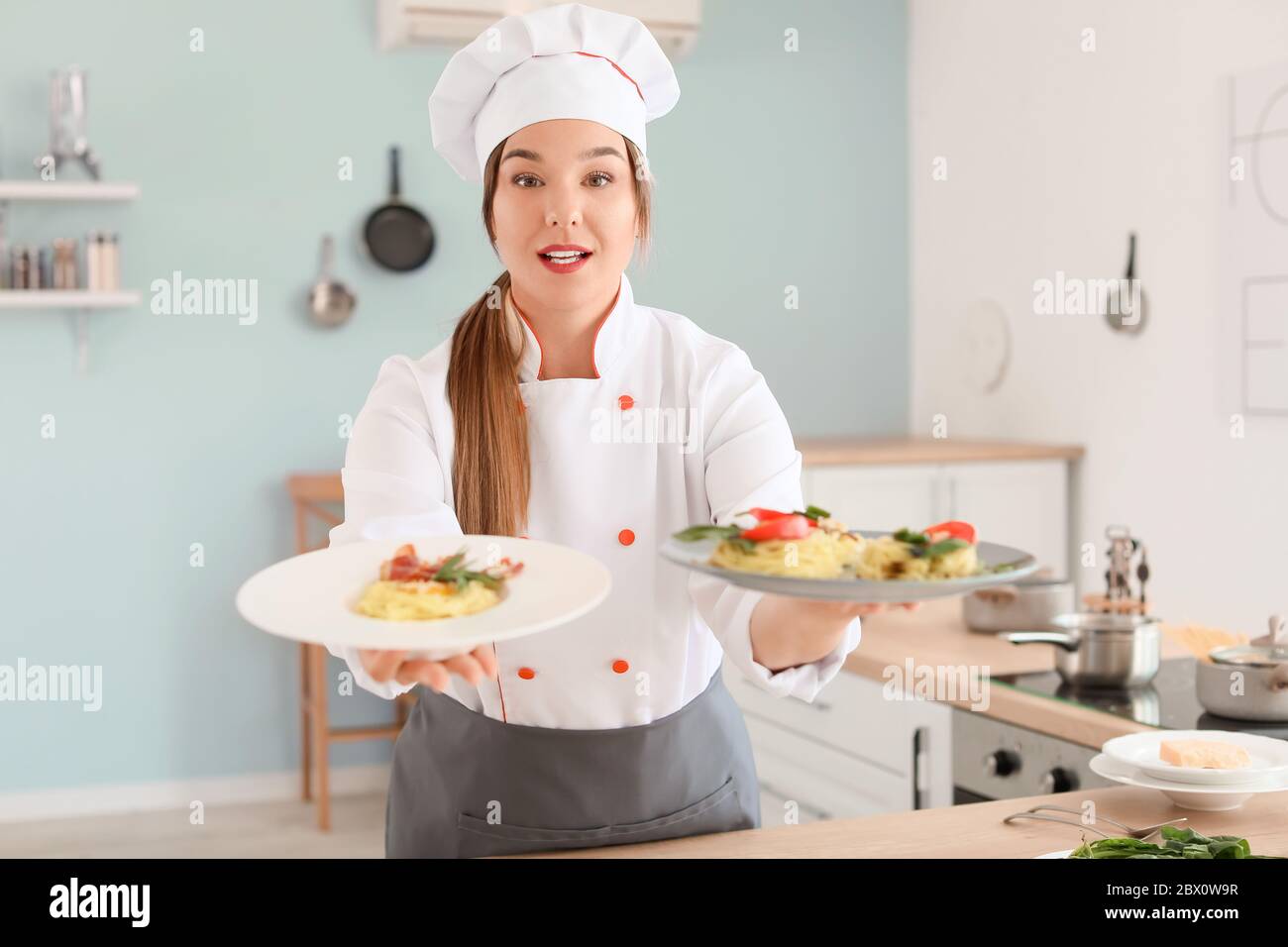 Female chef with tasty dishes in kitchen Stock Photo - Alamy
