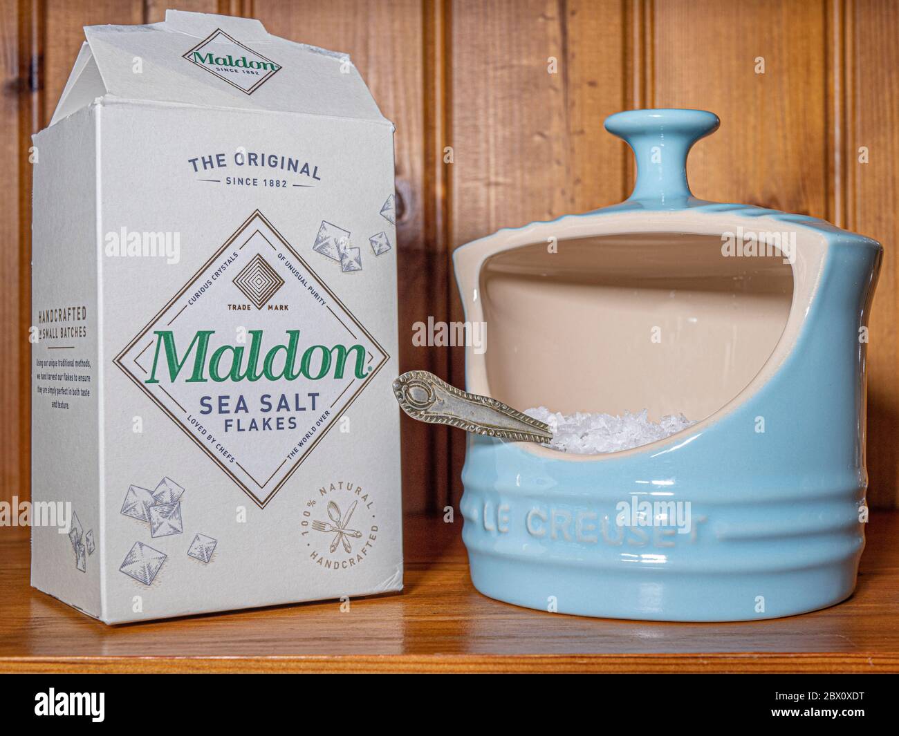 Packet of Maldon sea salt flakes next to a pale blue ceramic stoneware ...