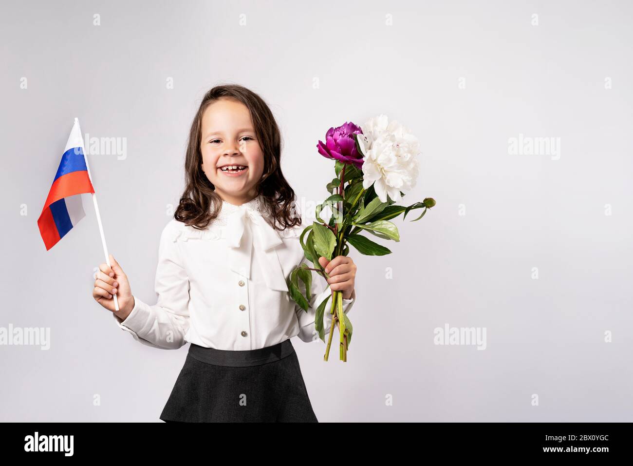a beautiful girl holds a flag in one hand, flowers in the other Stock ...