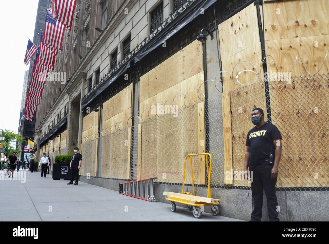 Security guards stand in front of the Saks Fifth Avenue store in New ...