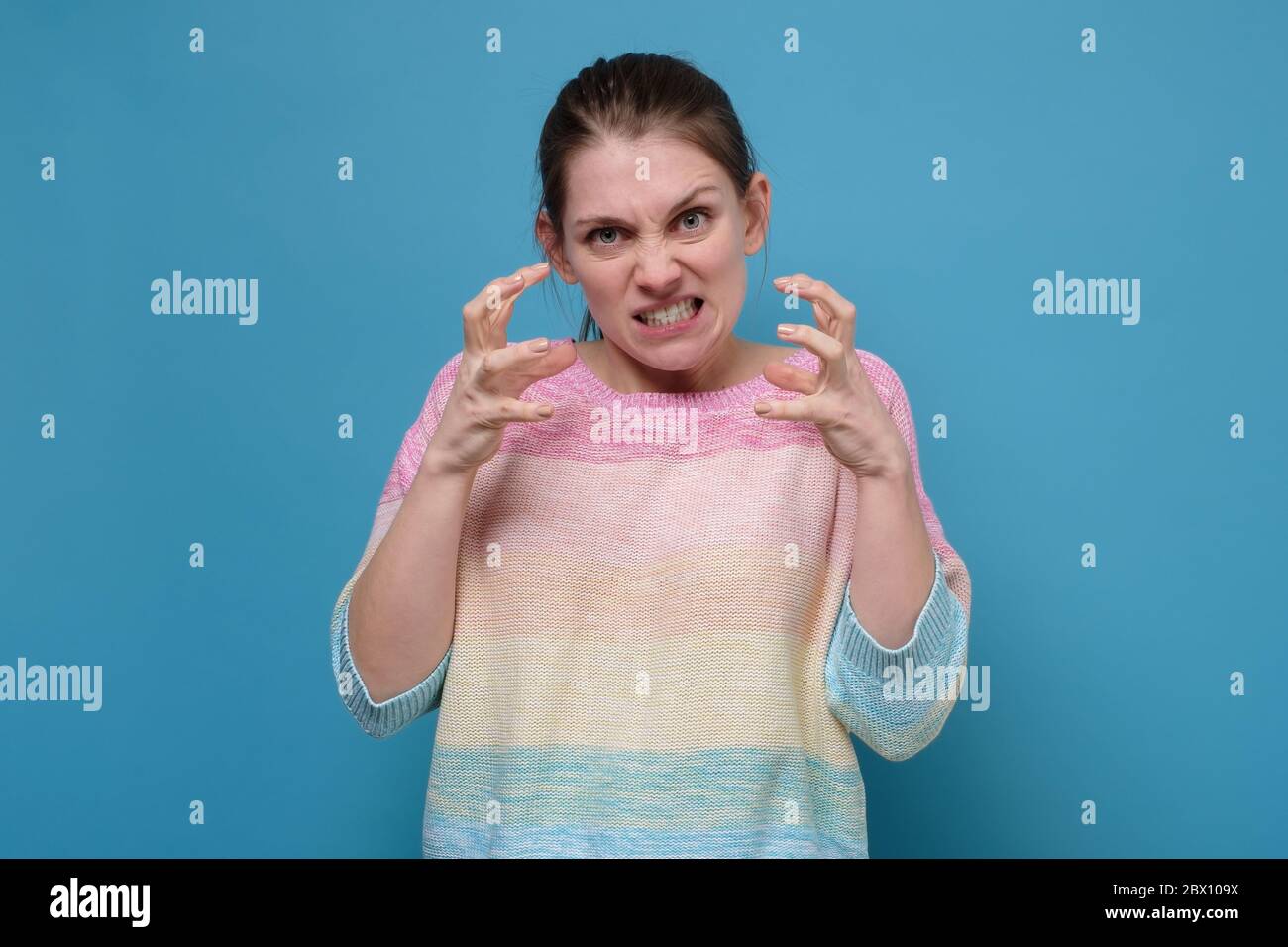 Young annoyed angry woman holding hands in furious gesture. Negative ...