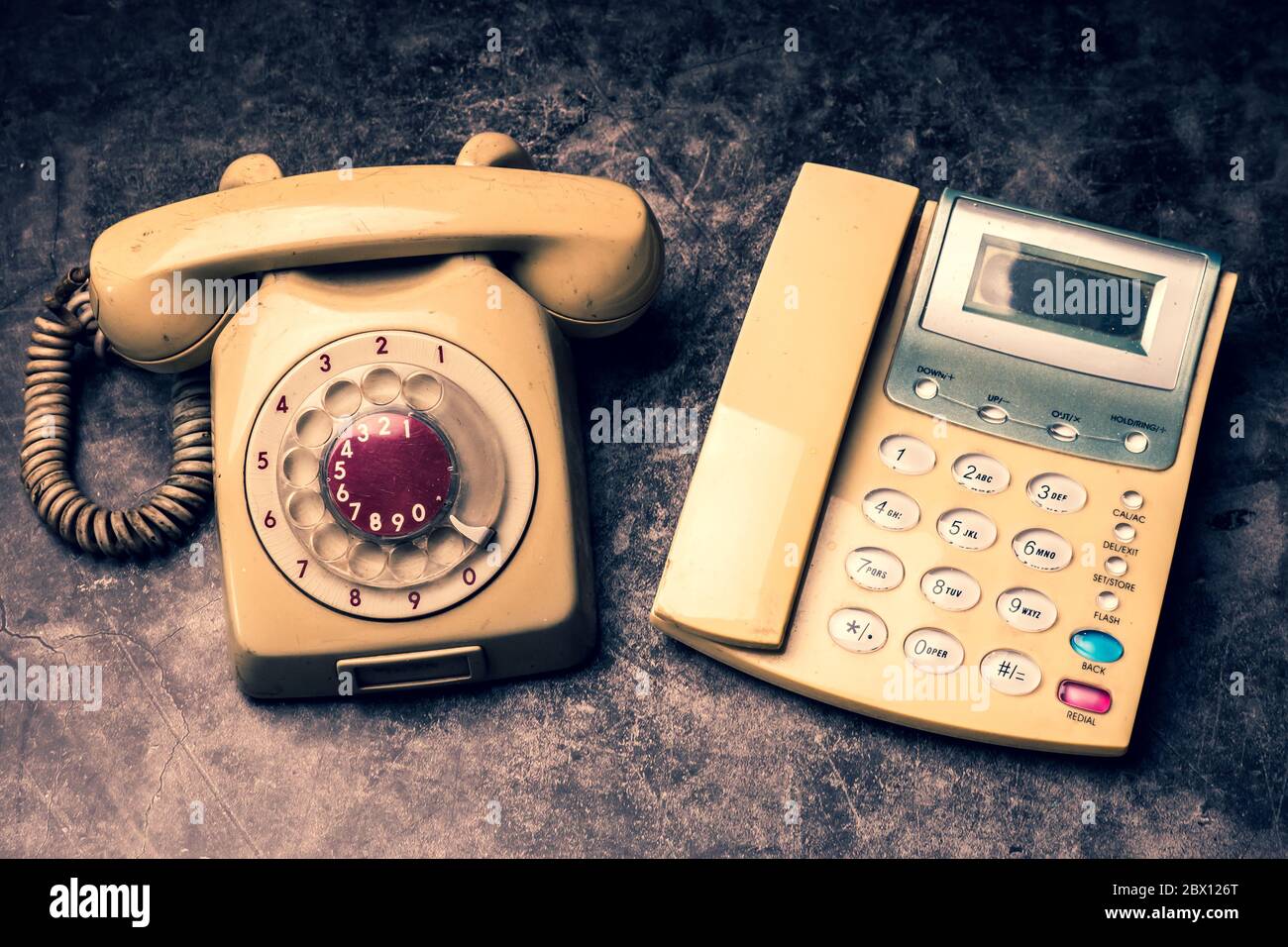 An old telephone with rotary dial and a landline on a grunge background ...