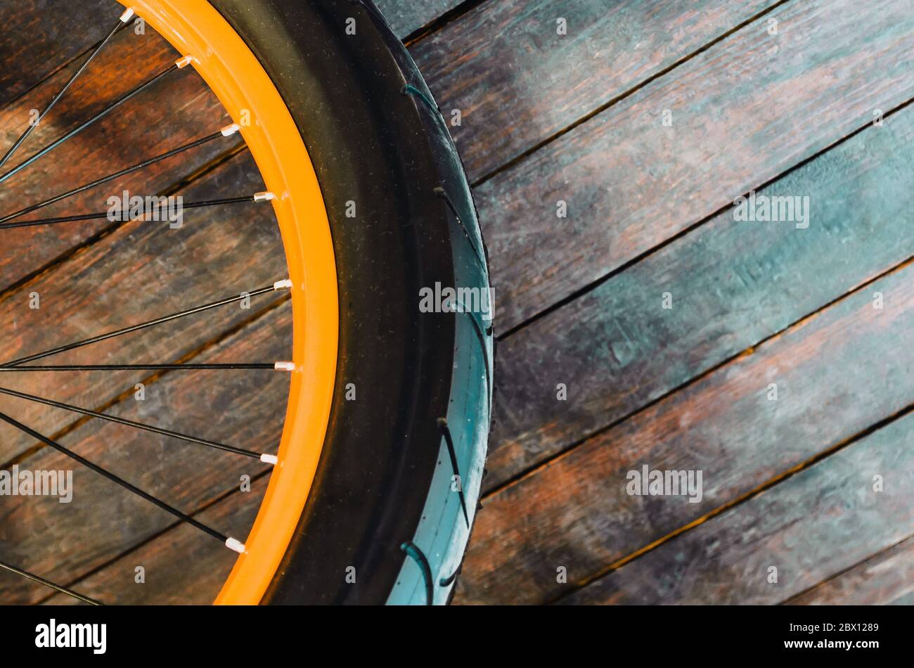 Wheel of a stylish bicycle with an orange rim and rubber tire cover ...