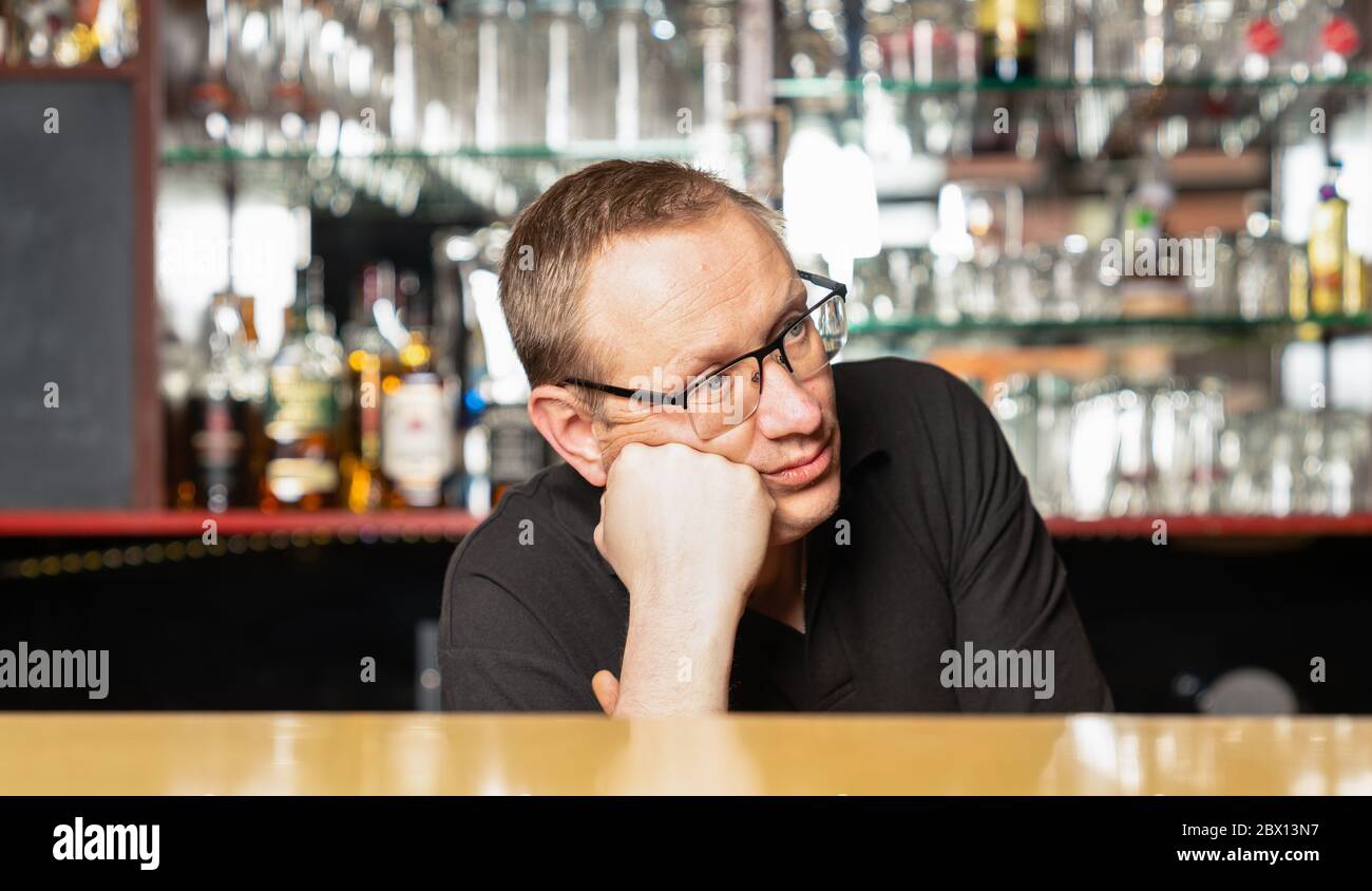 a pub host worries because of no guests in his pub Stock Photo - Alamy