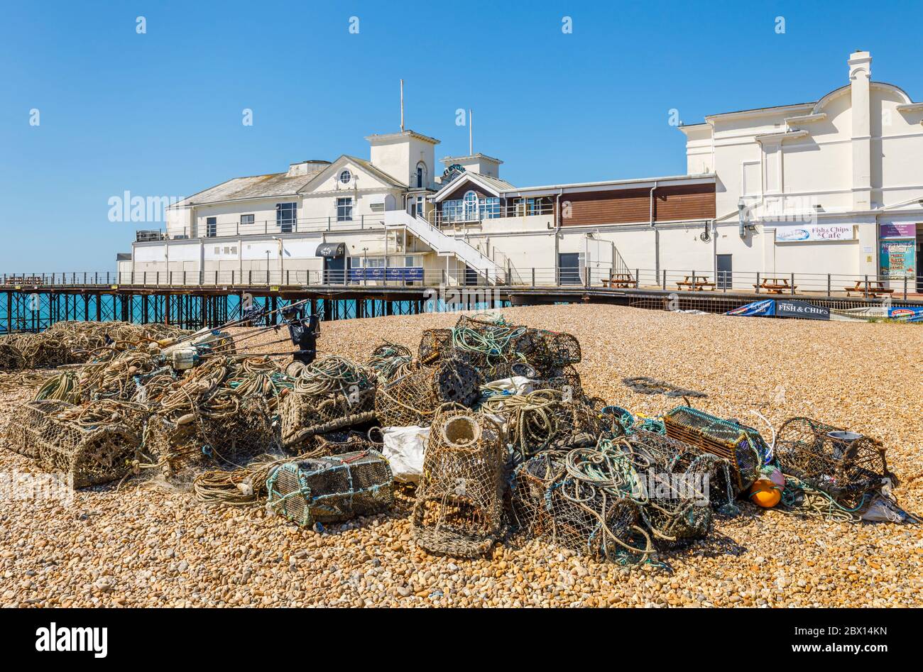 Lobster pots piled on the stony beach by the pier at Bognor Regis, a ...