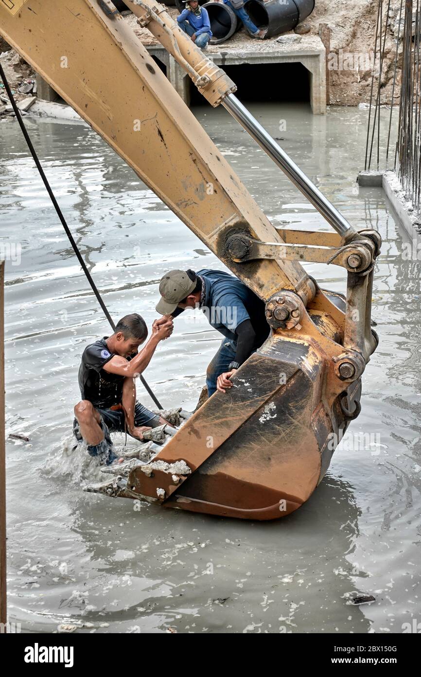 Construction worker in water working with a backhoe operator on ...