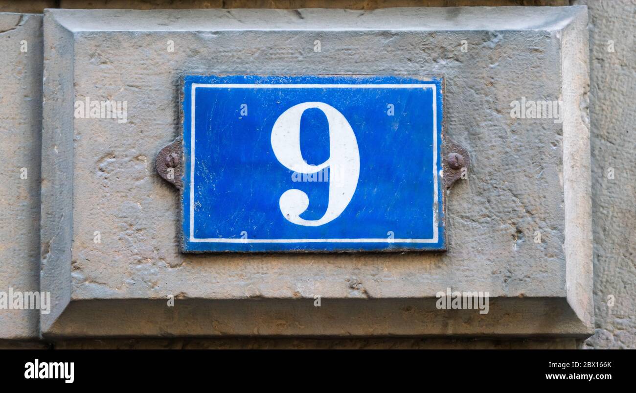 House number 9 White on blue on an old metal limestone wall of a ...
