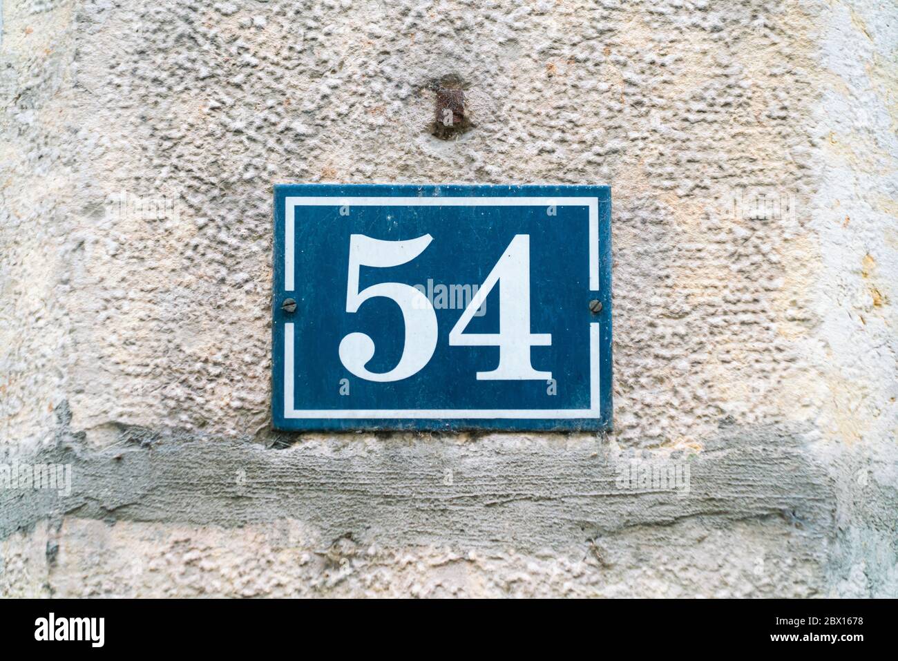 House number 54 on a old limestone wall of a authentic Franch house ...